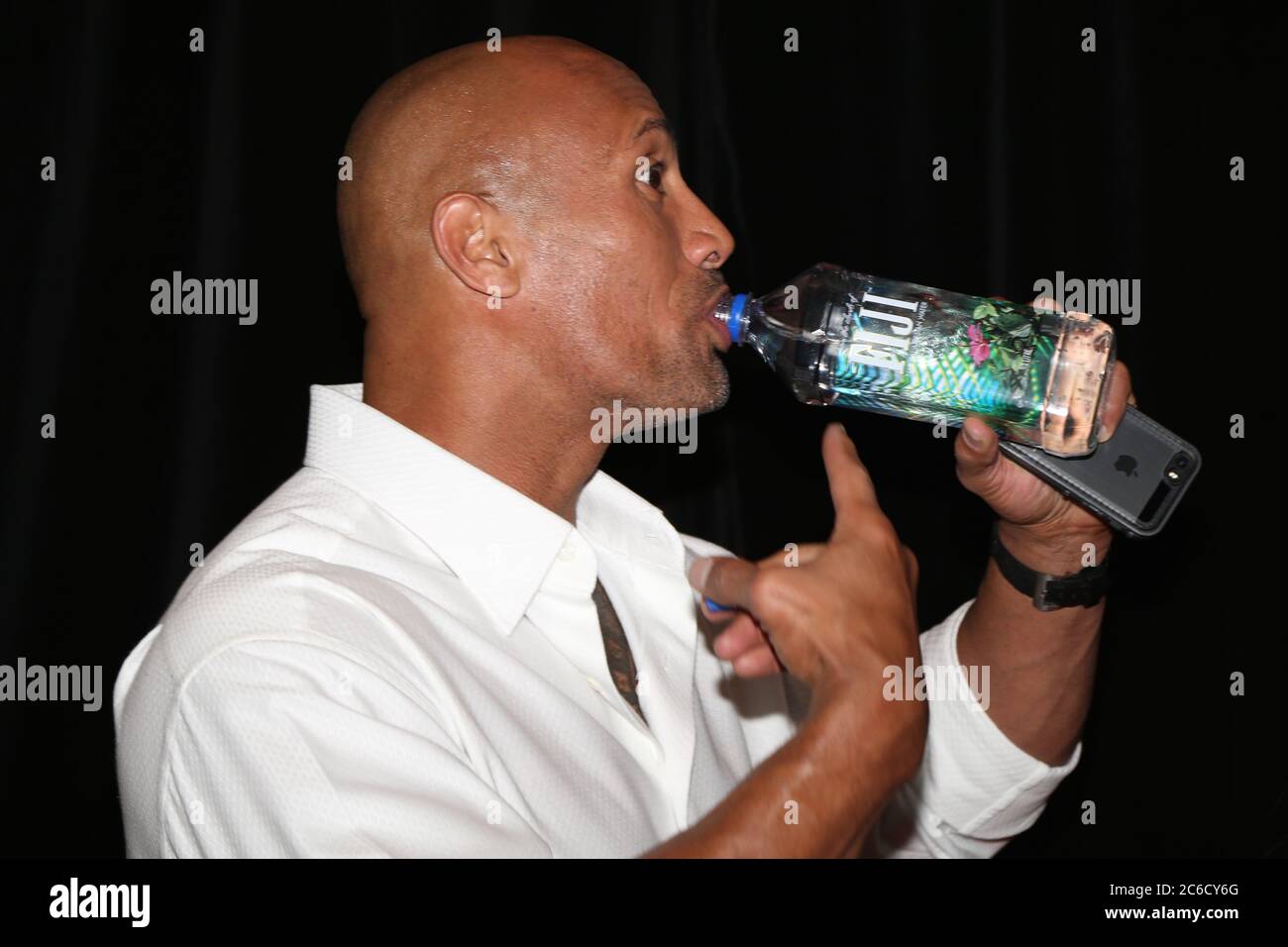 Thirsty work; Dwayne Johnson (The Rock) drinks some Fiji bottled water ...