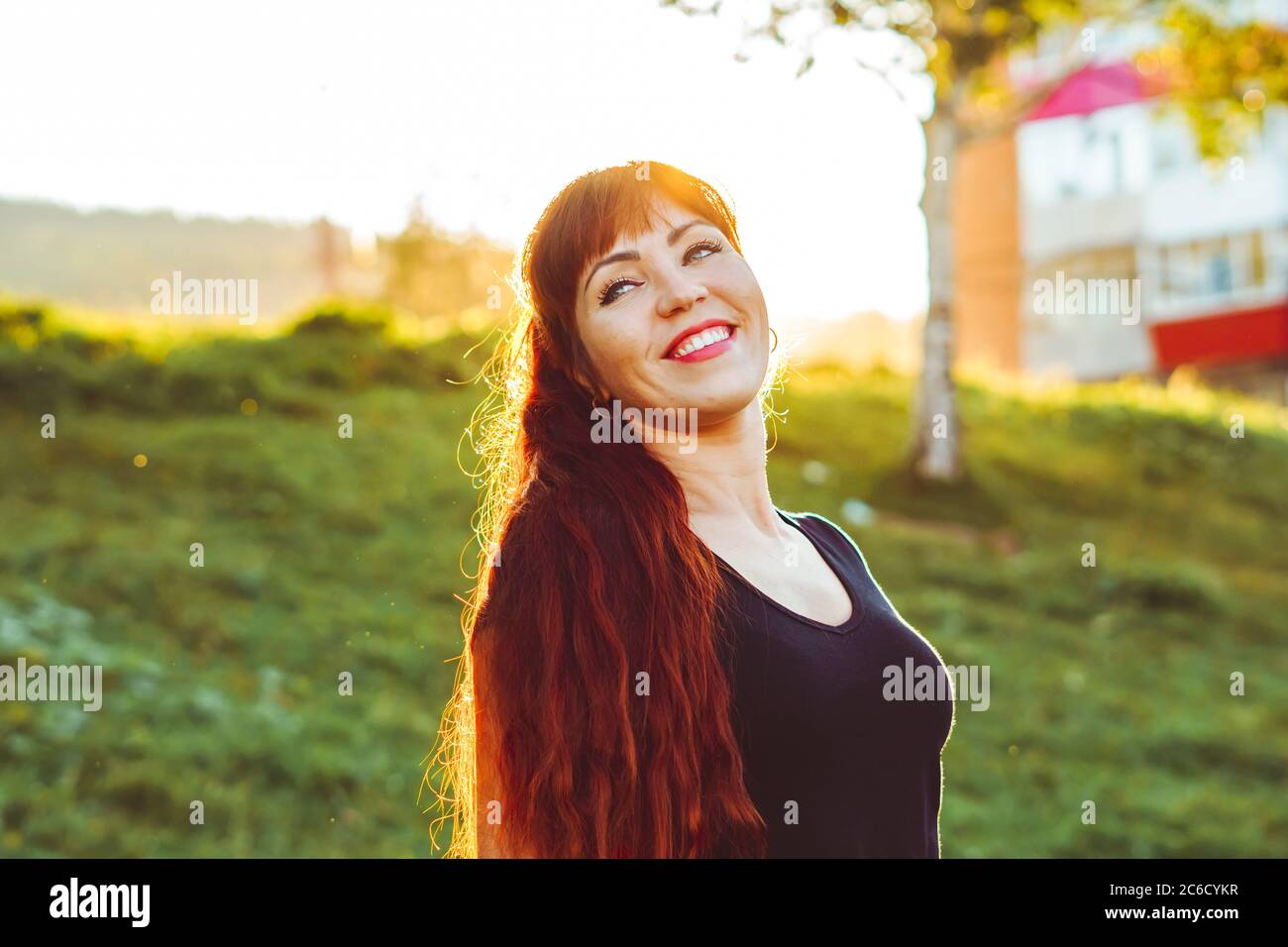 beautiful girl at sunset with long red hair in the sun Stock Photo - Alamy