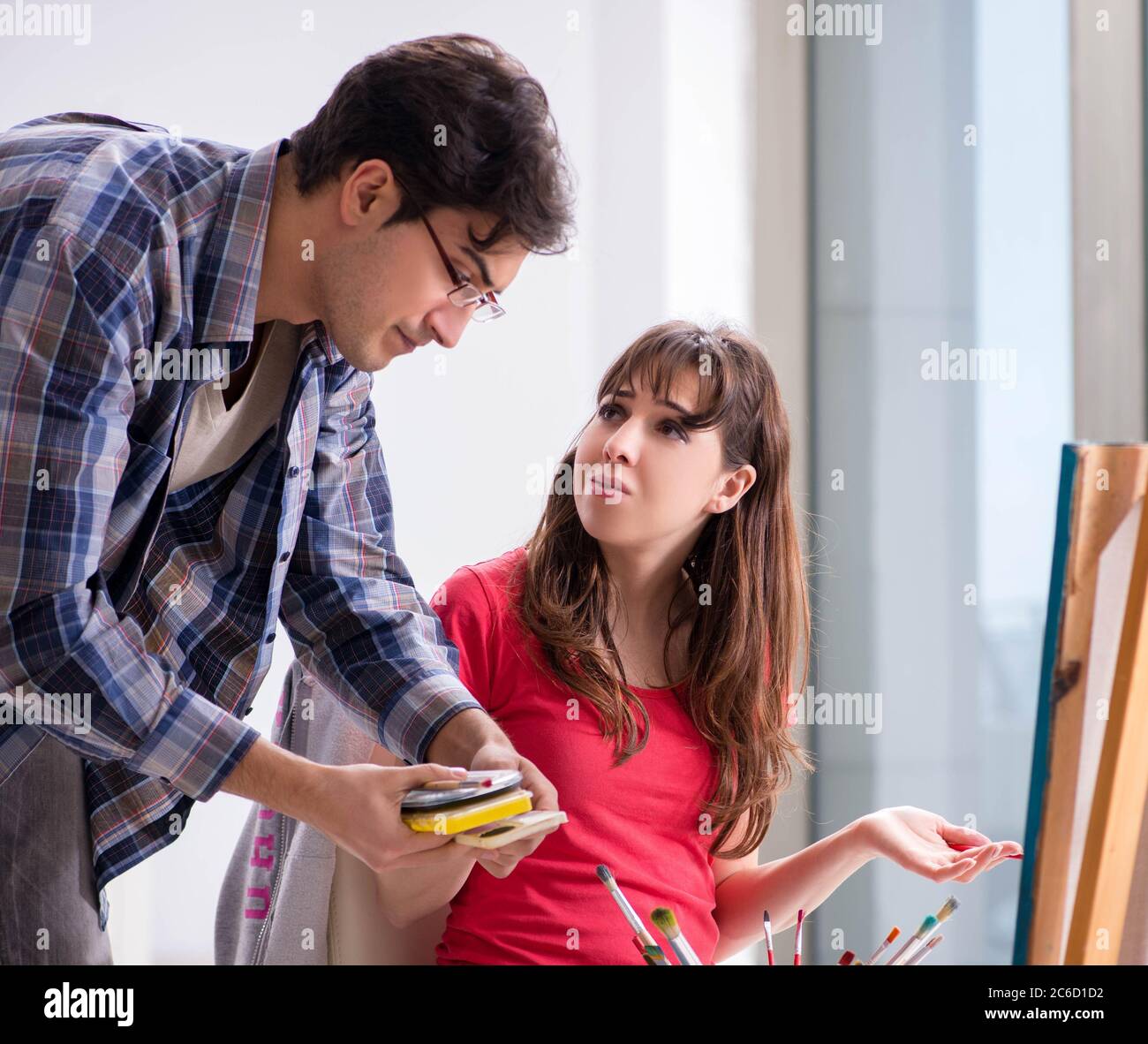The artist coaching student in painting class in studio Stock Photo - Alamy