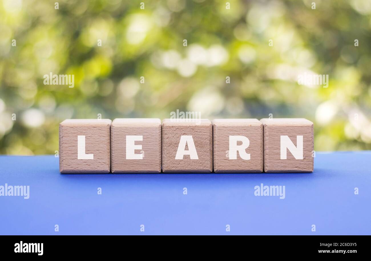 LEARN word written on wood cubes. Wooden blocks against blurred natural ...