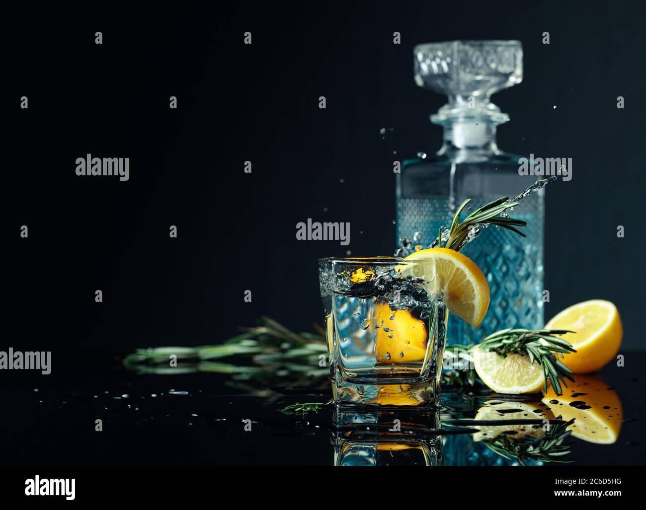 Cocktail gin-tonic with lemon slices and twigs of rosemary. Piece of ...