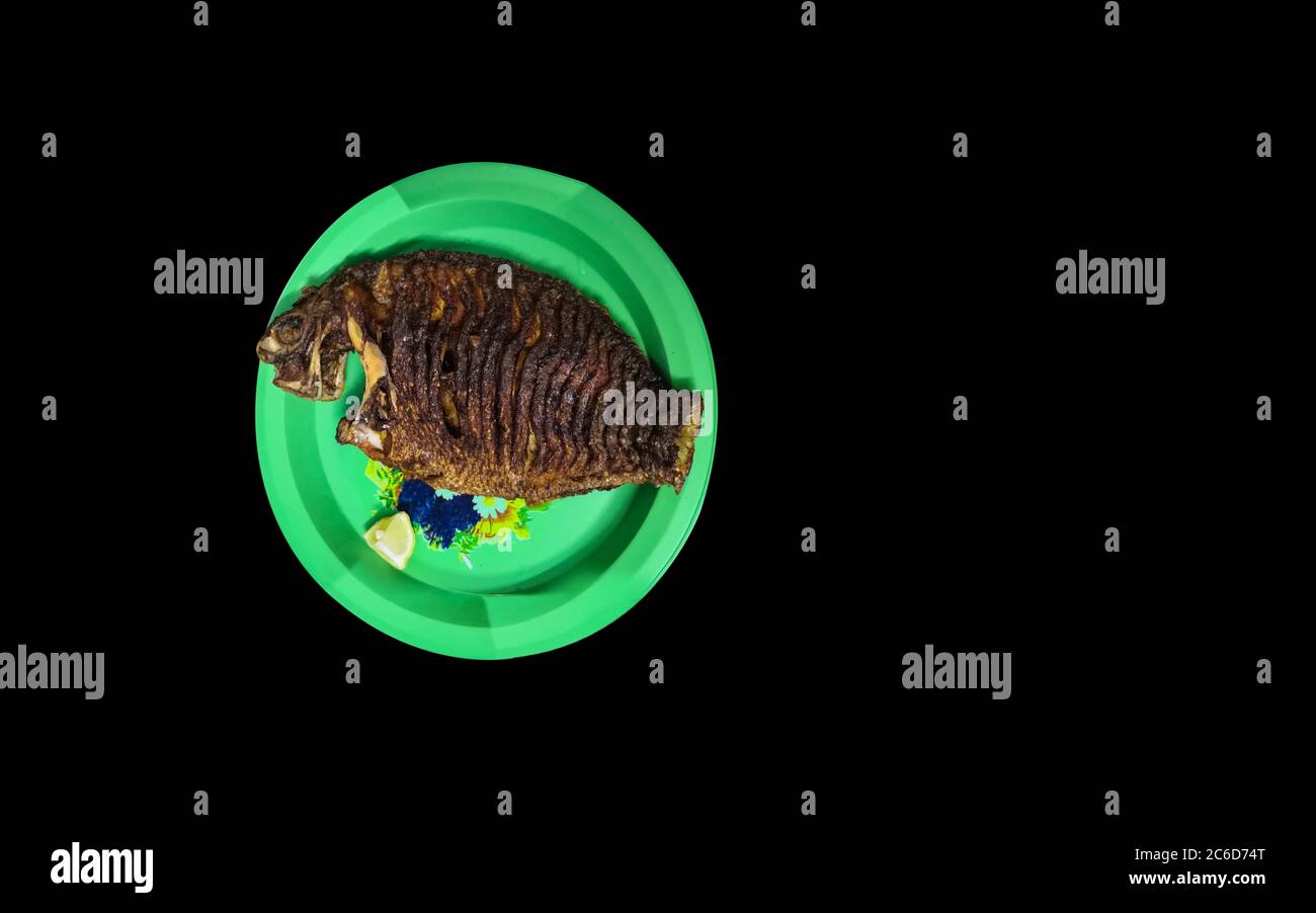 fish fry with plate isolated on black background Stock Photo - Alamy