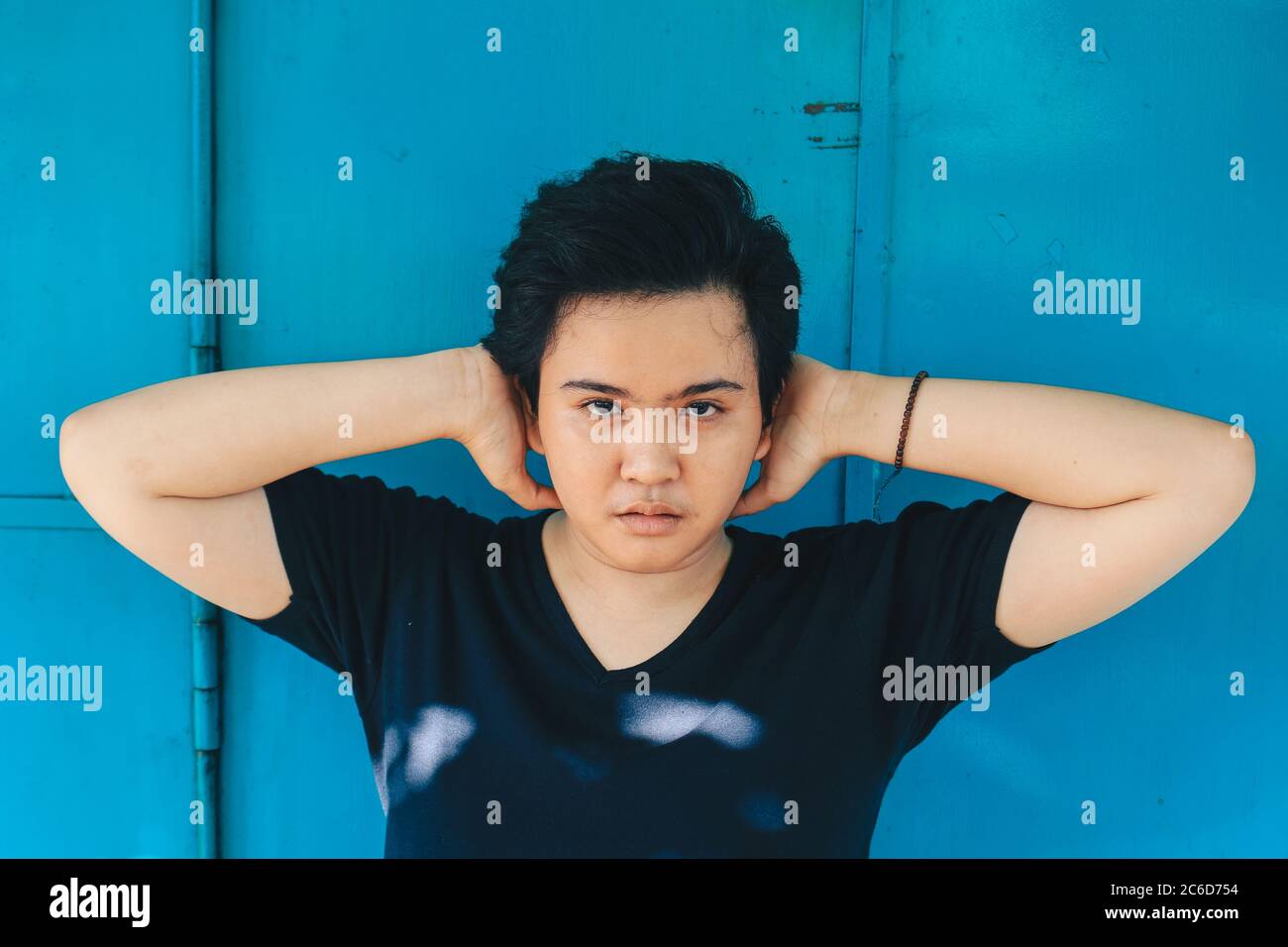 Asian beautiful short hair girl on blue background with sharp looking ...