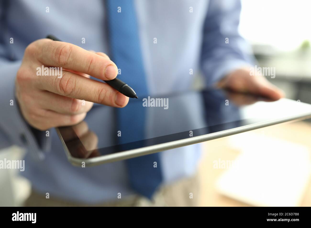Man holds tablet and digitally signs Stock Photo - Alamy