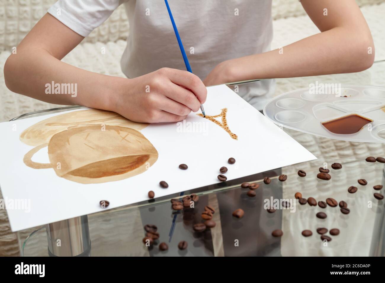 Coffee drawings. Girl draws a coffee cup using coffee instead of paints ...