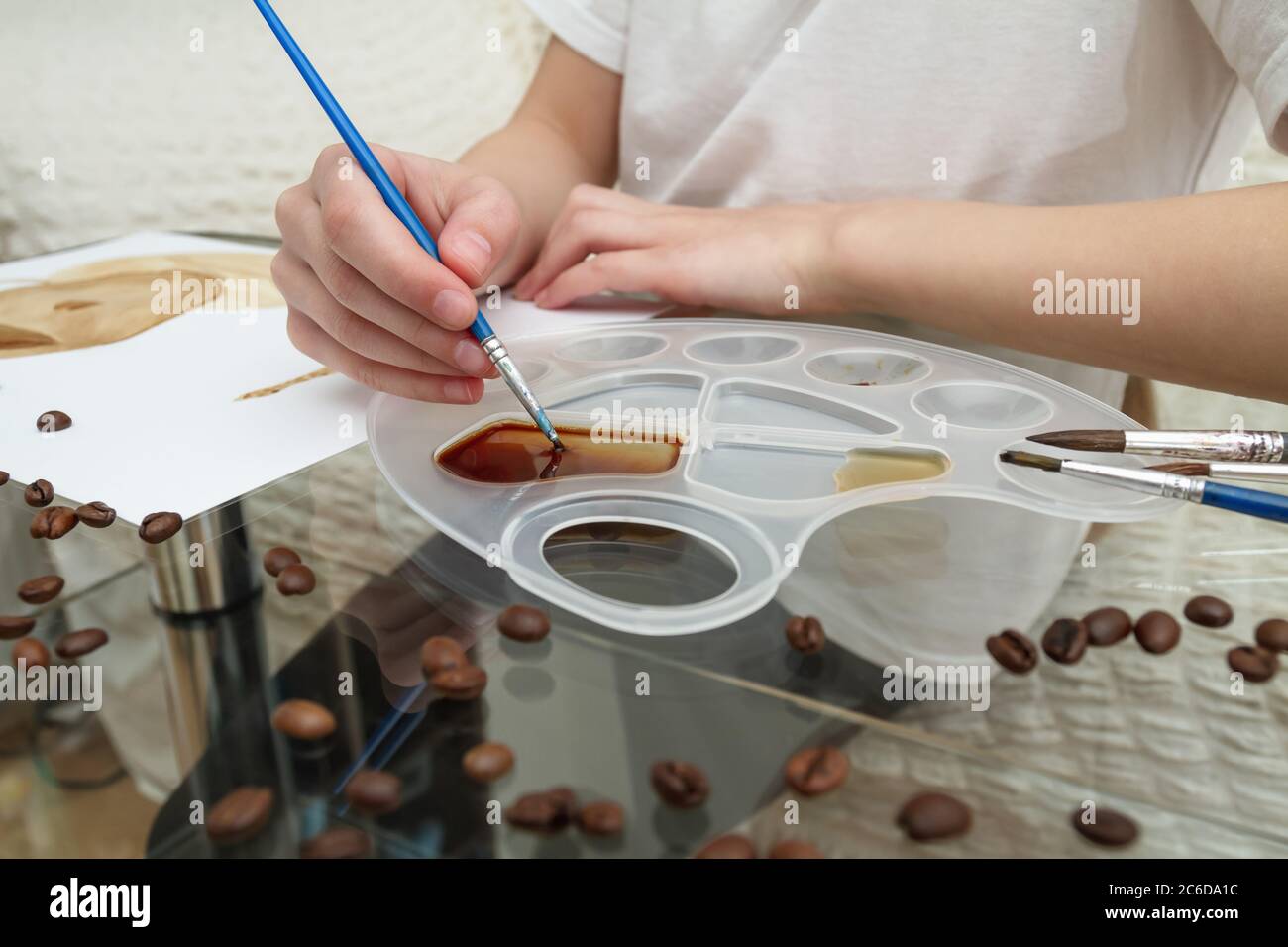 Coffee drawings. Girl draws a coffee cup using coffee instead of paints ...