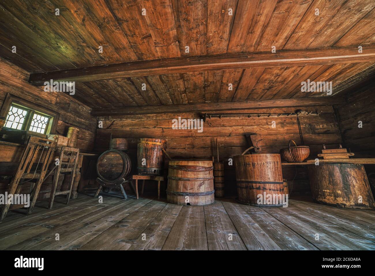 A medieval interior recreation with wooden desk, barrels and chairs in ...