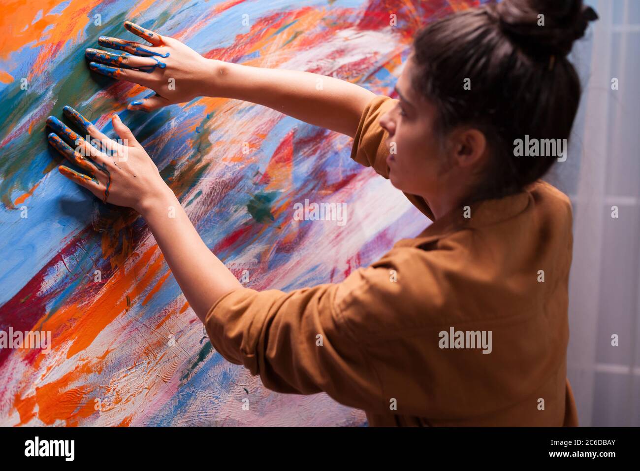 Painting with fingers on large canvas in art studio. Modern artwork paint on canvas, creative ...