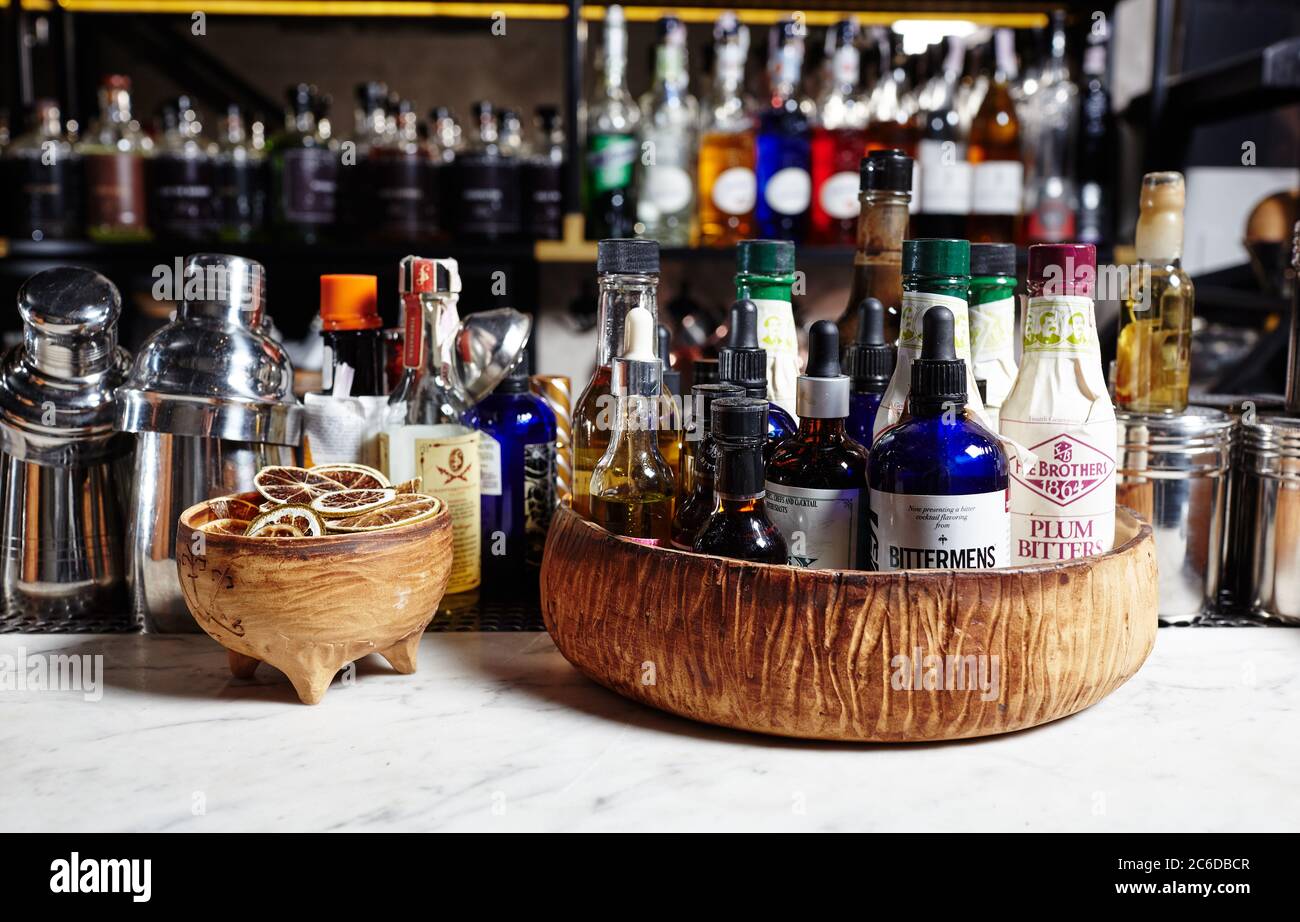 Ingredients for cocktails in small bottles.Shakers and lemon wedges on ...