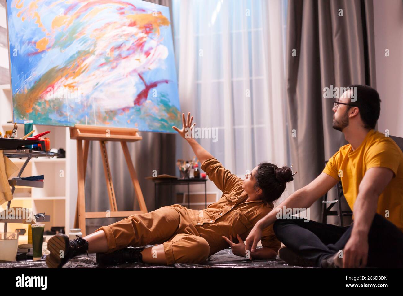 Young artist looking at colorful painting in art workshop. Modern ...