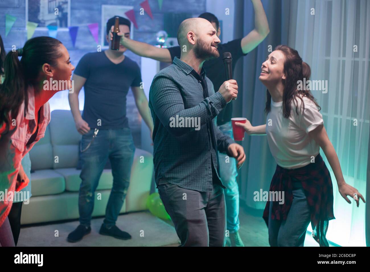 Young man and his best friend singing on microphone at the party Stock ...