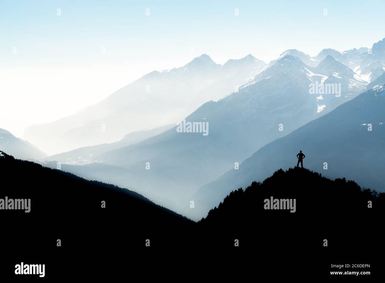 Spectacular mountain ranges silhouettes. Man reaching summit enjoying ...