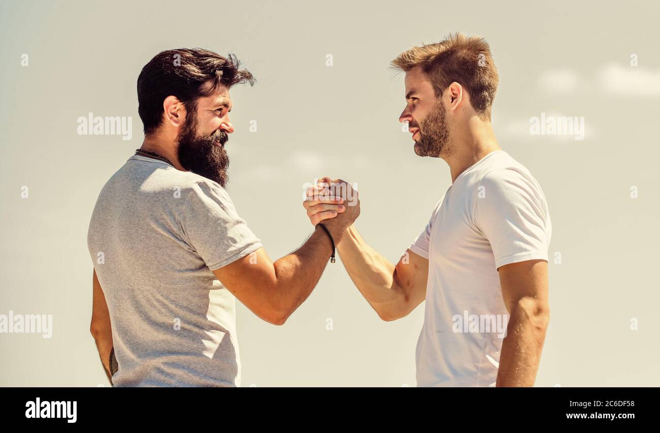 Strong and muscular arms. Successful deal handshake blue sky background ...