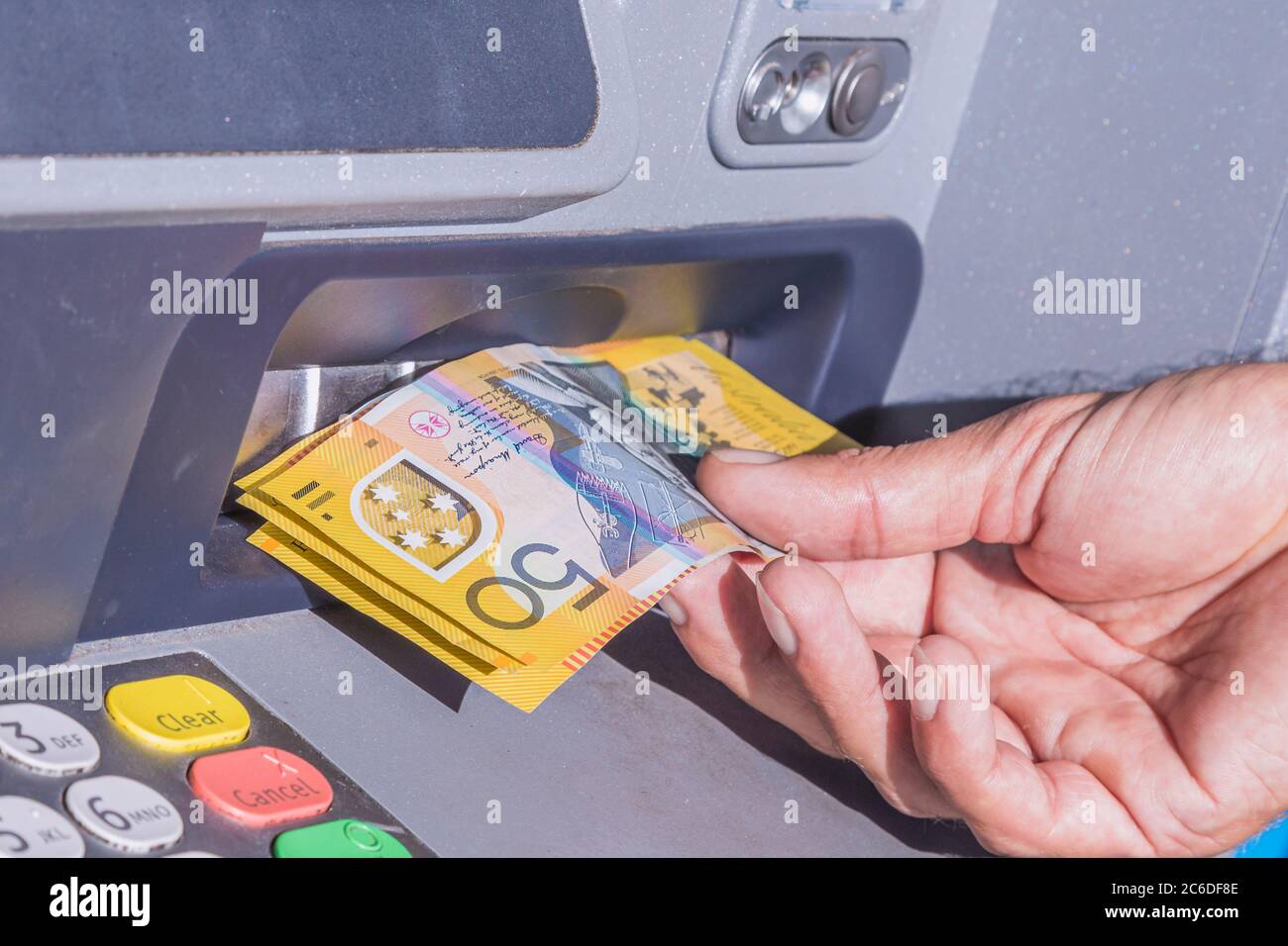 Taking several Australian $50 notes from an ATM machine Stock Photo - Alamy