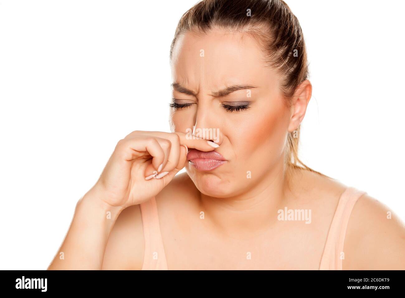 A young woman has itching in the nose on white background Stock Photo ...