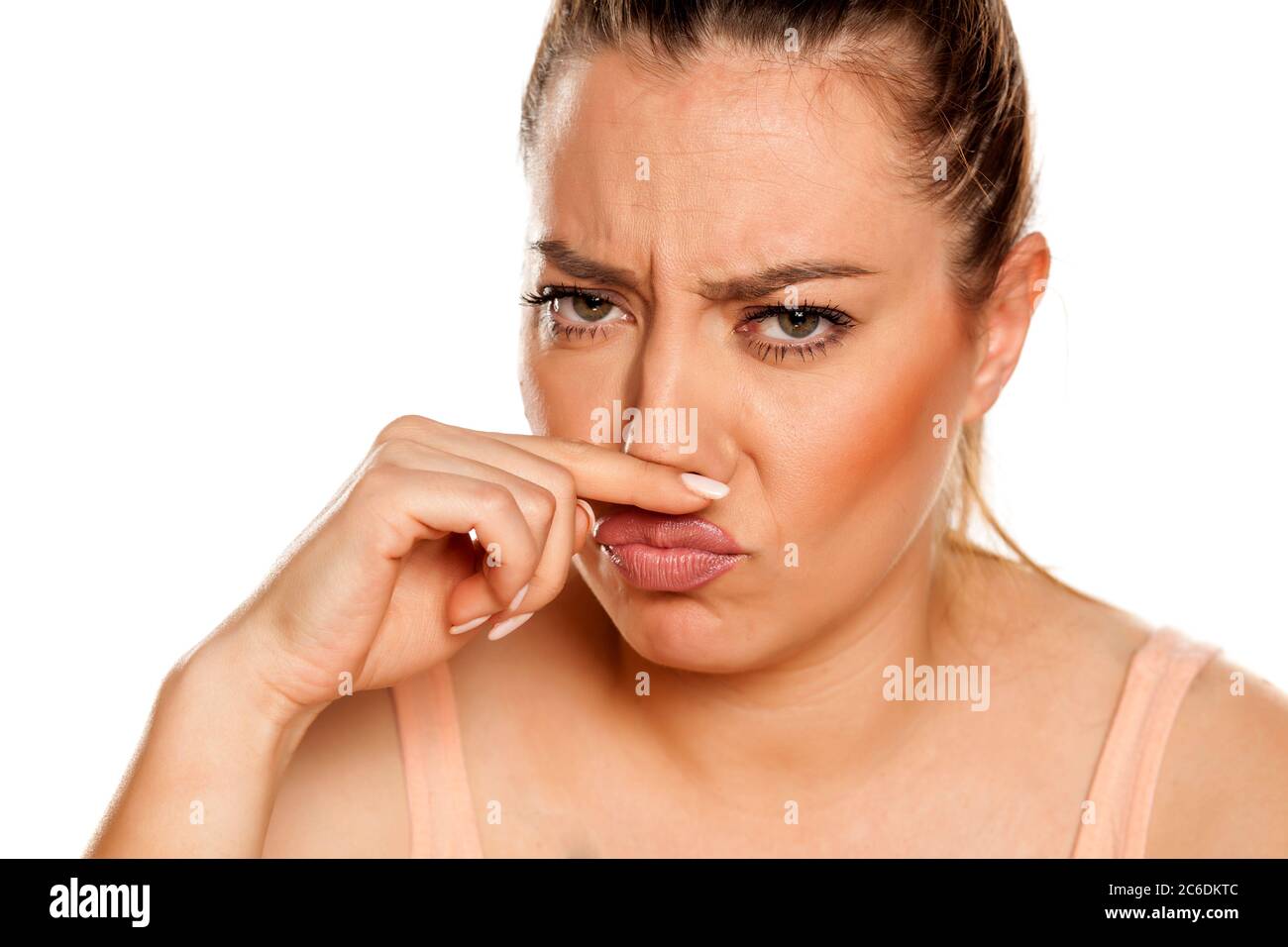 A young woman has itching in the nose on white background Stock Photo ...