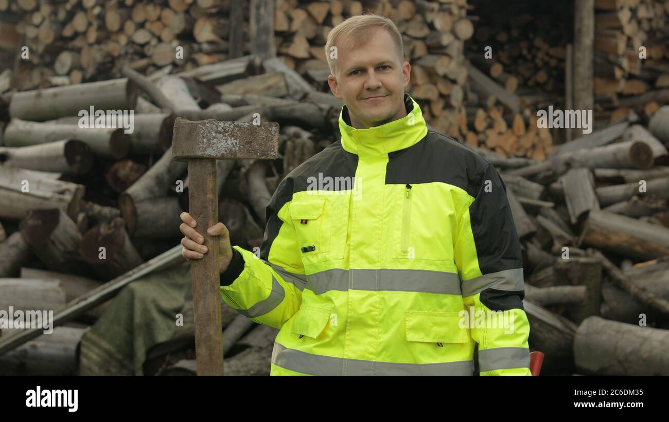 Portrait of lumberjack posing in green jacket with reflective stripes ...