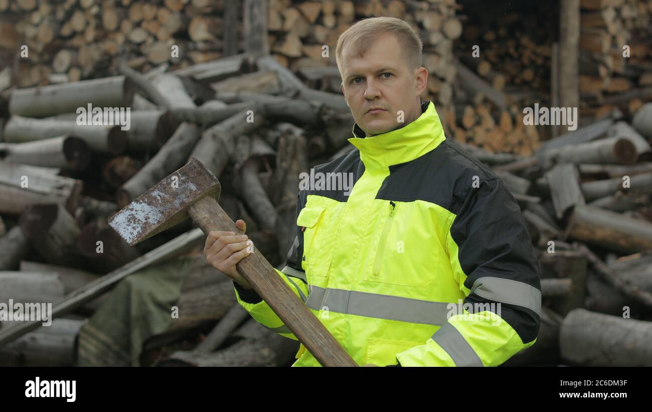 Portrait of lumberjack posing in green jacket with reflective stripes ...