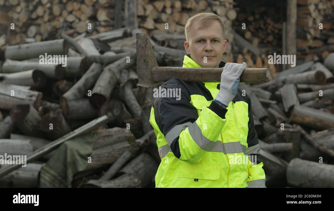 Portrait of lumberjack posing in green jacket with reflective stripes ...