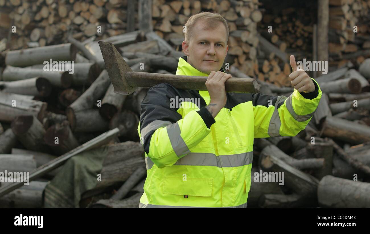 Lumberjack posing in green jacket with reflective stripes and holds big ...
