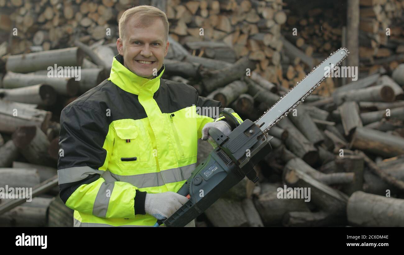 Portrait of lumberjack posing in green jacket with reflective stripes ...