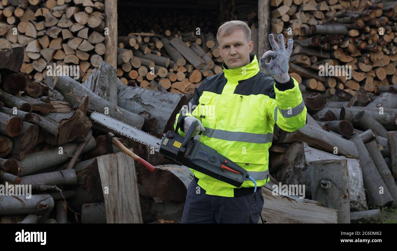 Lumberjack posing in green jacket with reflective stripes and holds ...