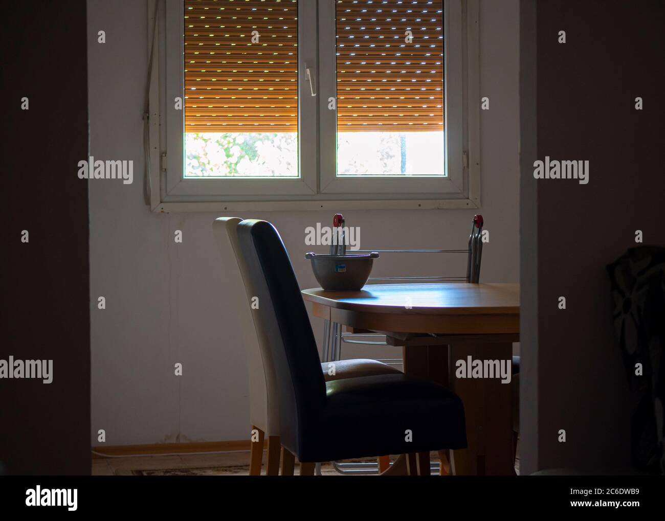 table chairs window light in dark room Stock Photo - Alamy