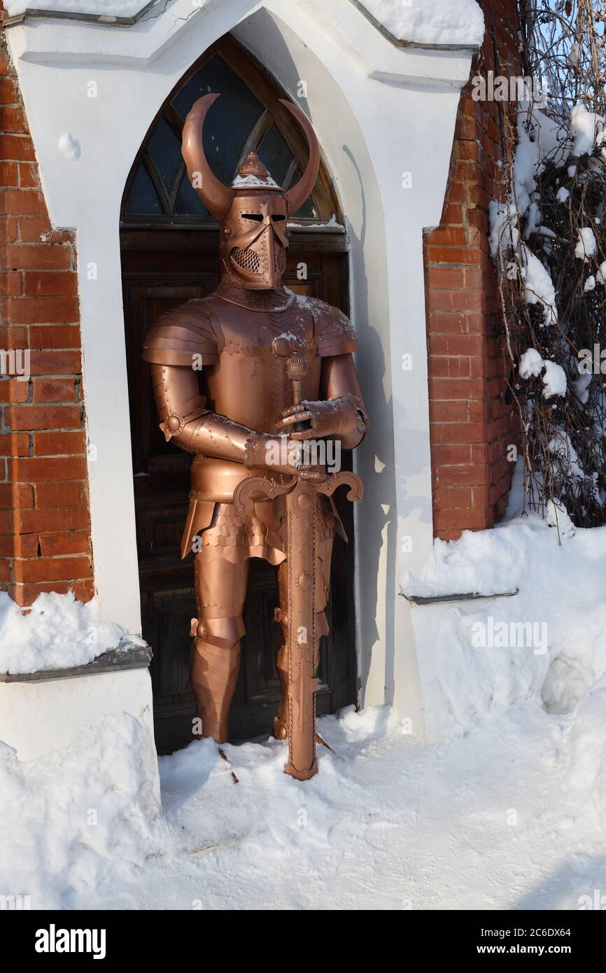 Knight armor with sword guards the gates at winter. Modern replica ...