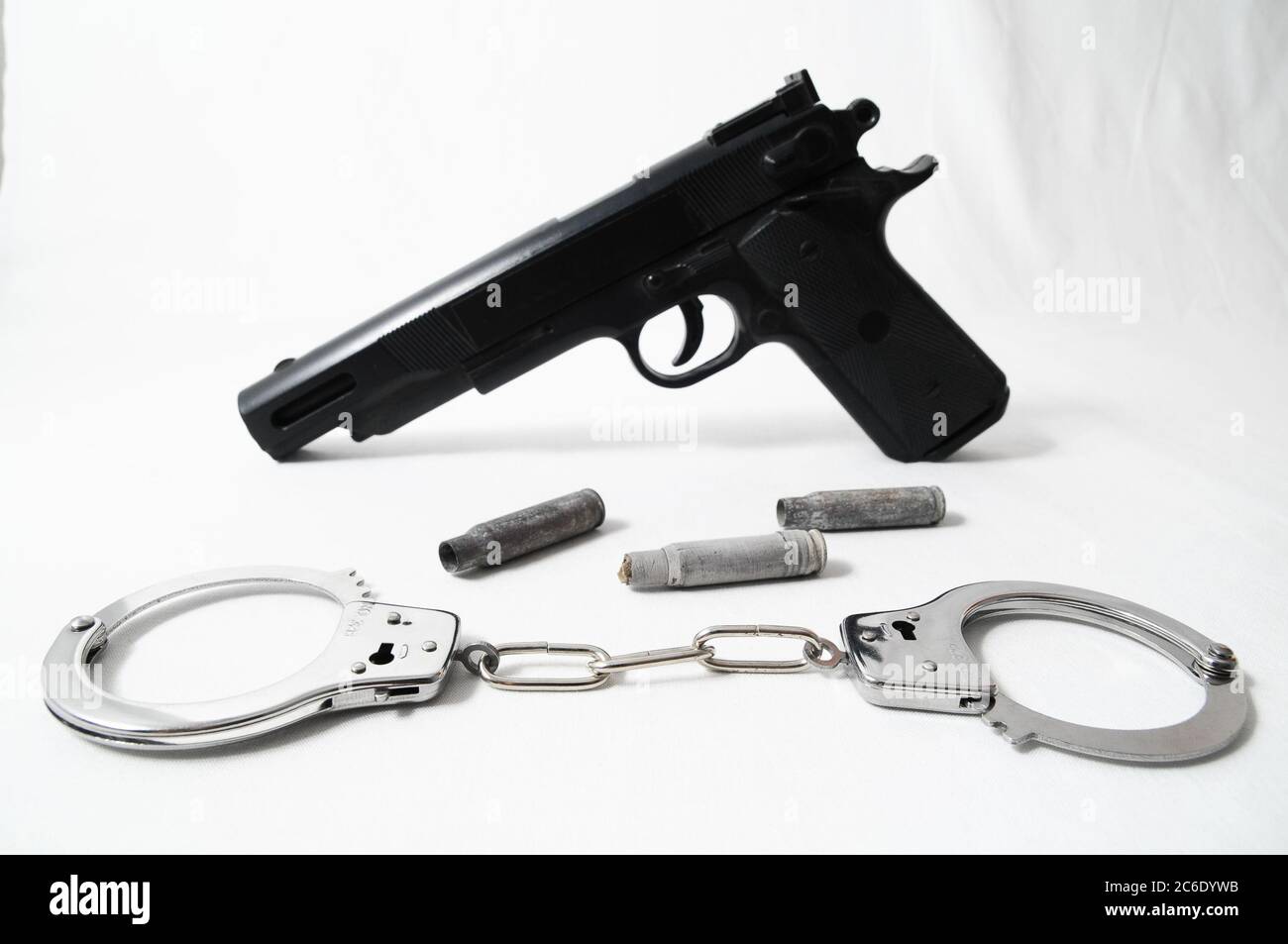 Pistol Gun and Handcuffs on a White Background Stock Photo - Alamy