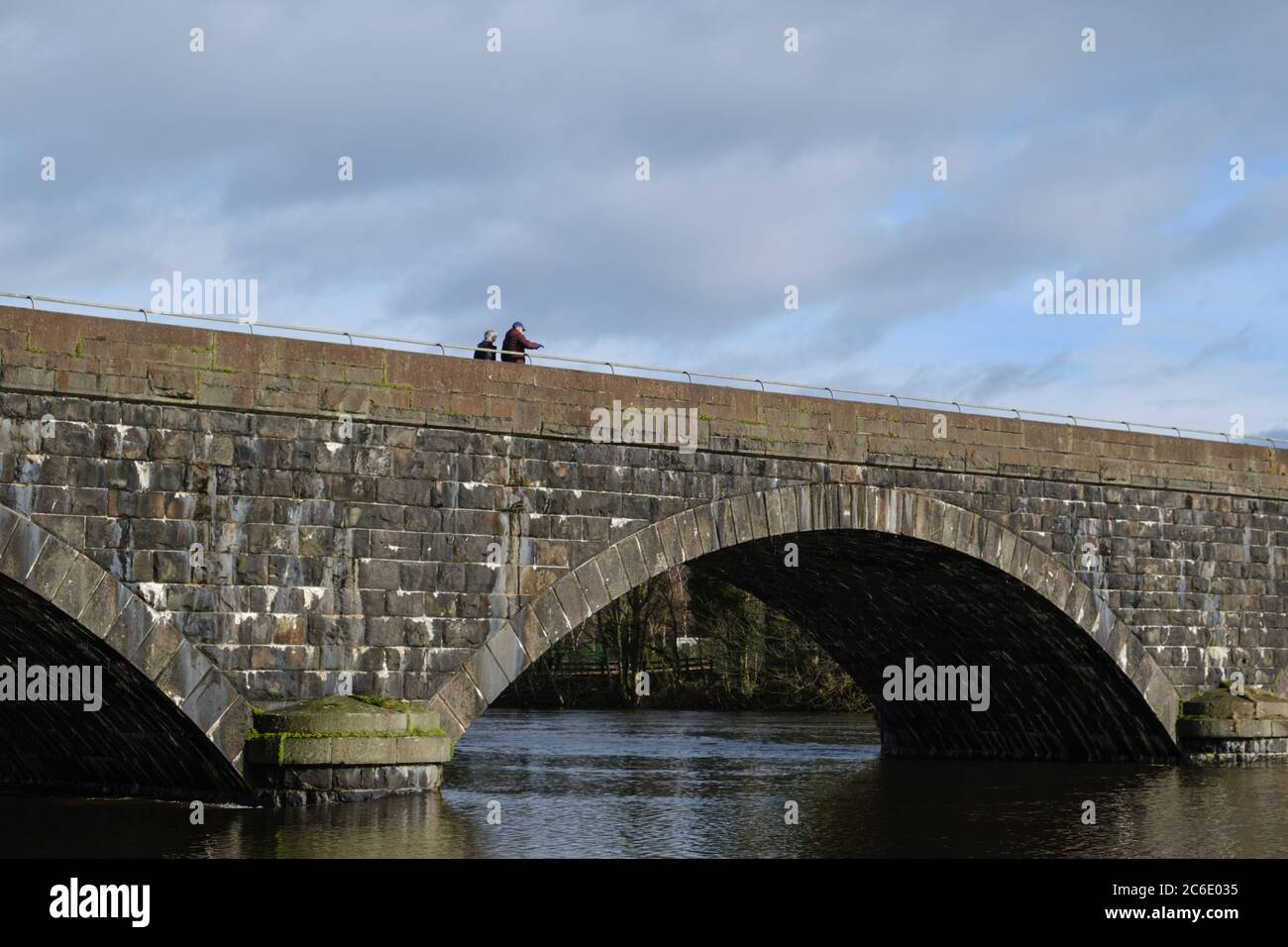 A couple walk across the bridge over the River Bann at Portglenone in ...
