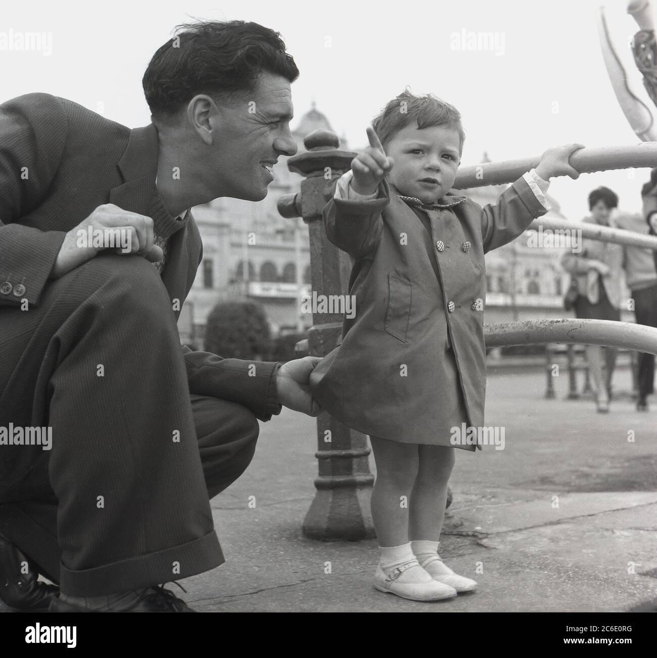 1950s, historical, 'look daddy'''...at a seafront, a father kneeling ...