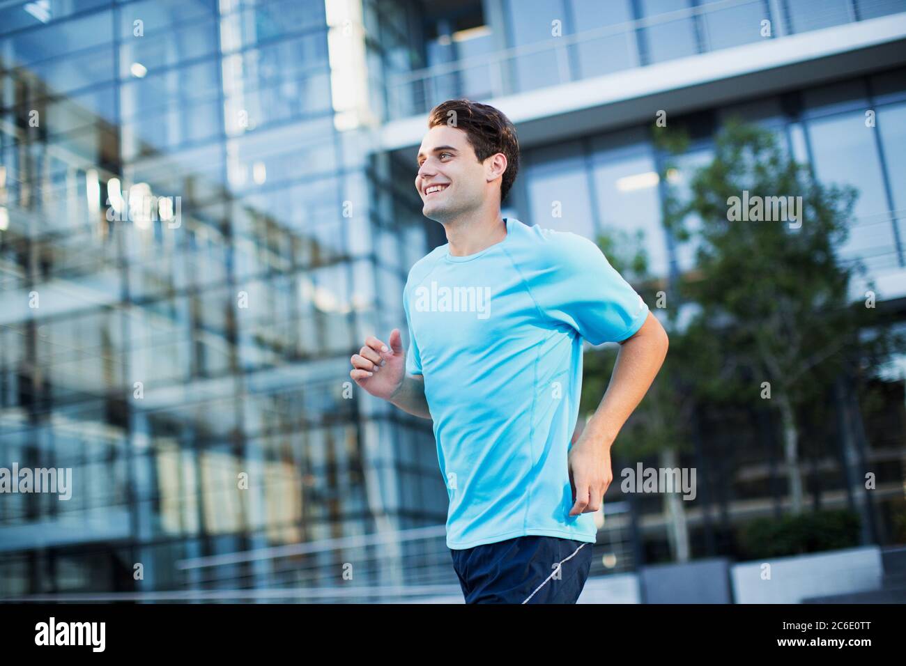 Young man jogging by building hi-res stock photography and images - Alamy
