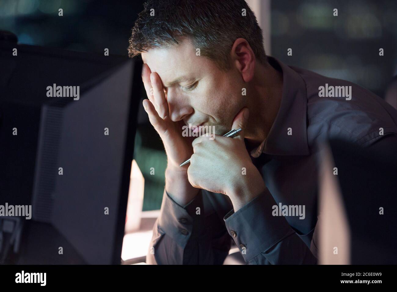 Tired businessman working late at computer Stock Photo - Alamy