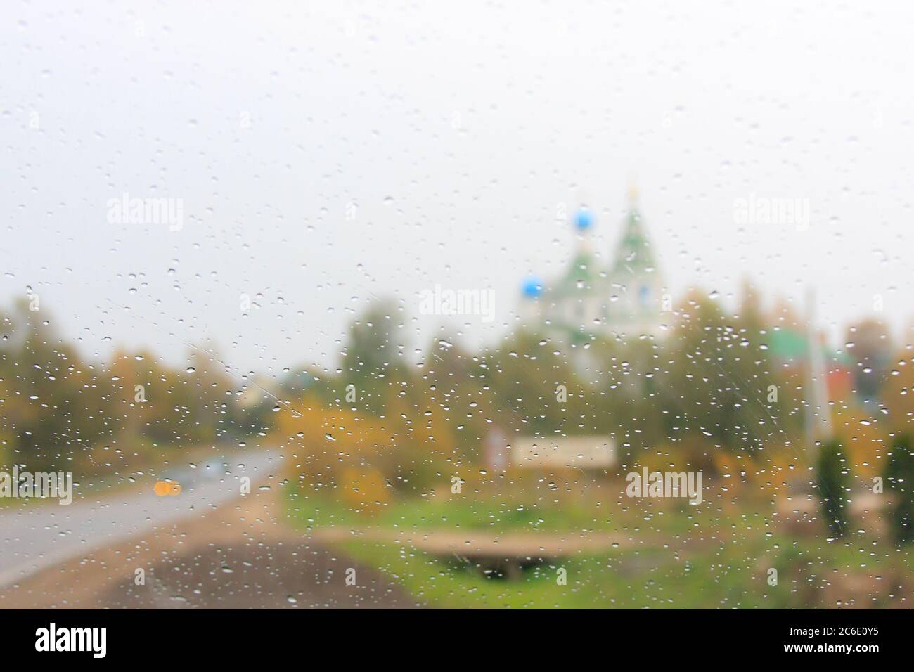 Rainy autumn day, view of the autumn forest and the church through the ...