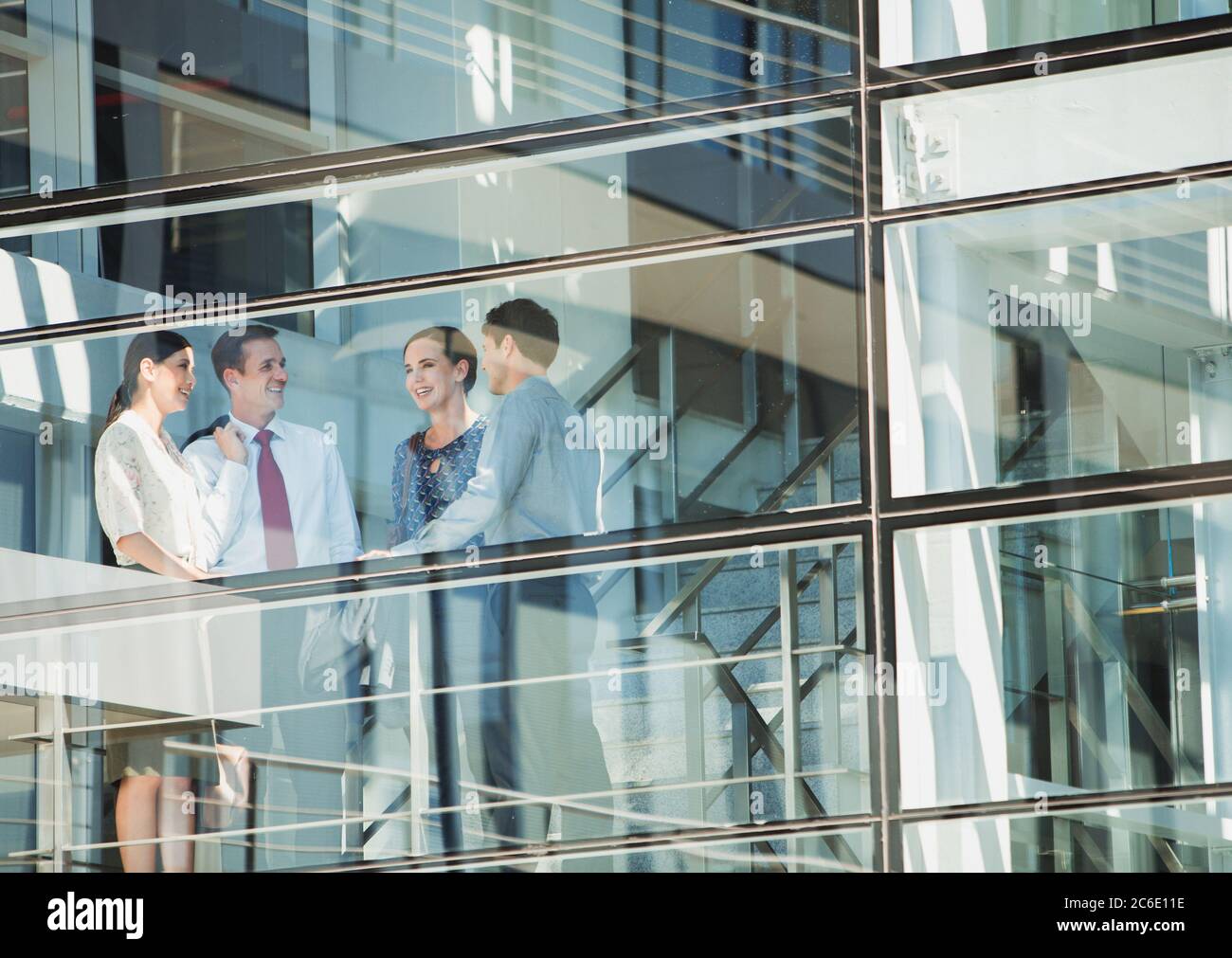 Business people talking at window Stock Photo - Alamy