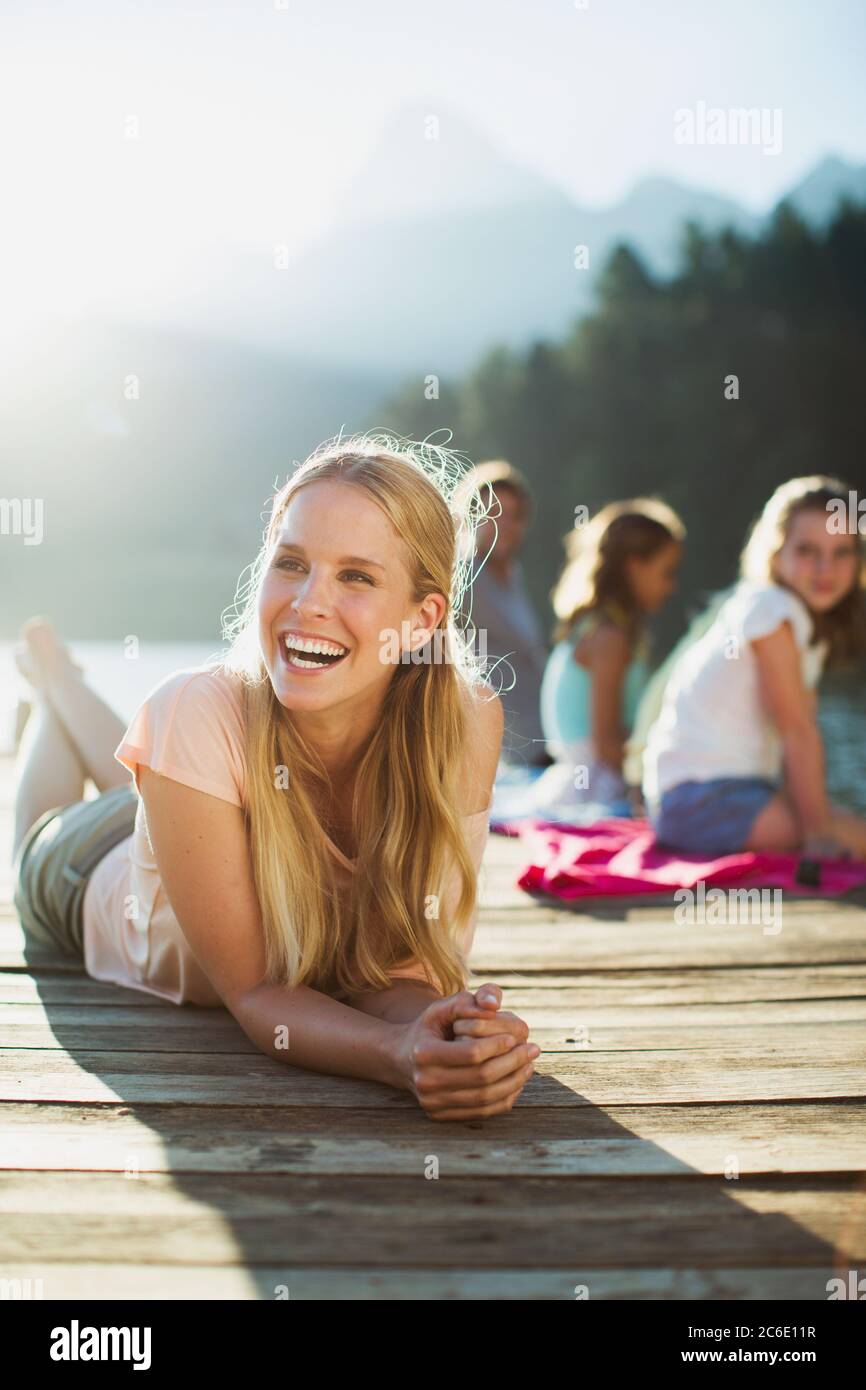 Woman laying on dock and laughing Stock Photo - Alamy