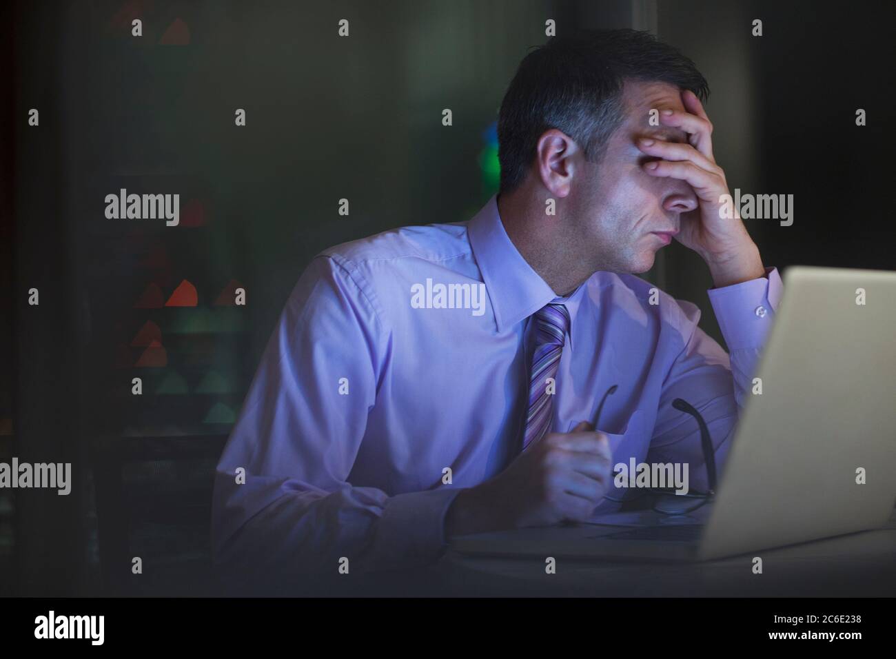 Tired businessman working late at laptop Stock Photo - Alamy