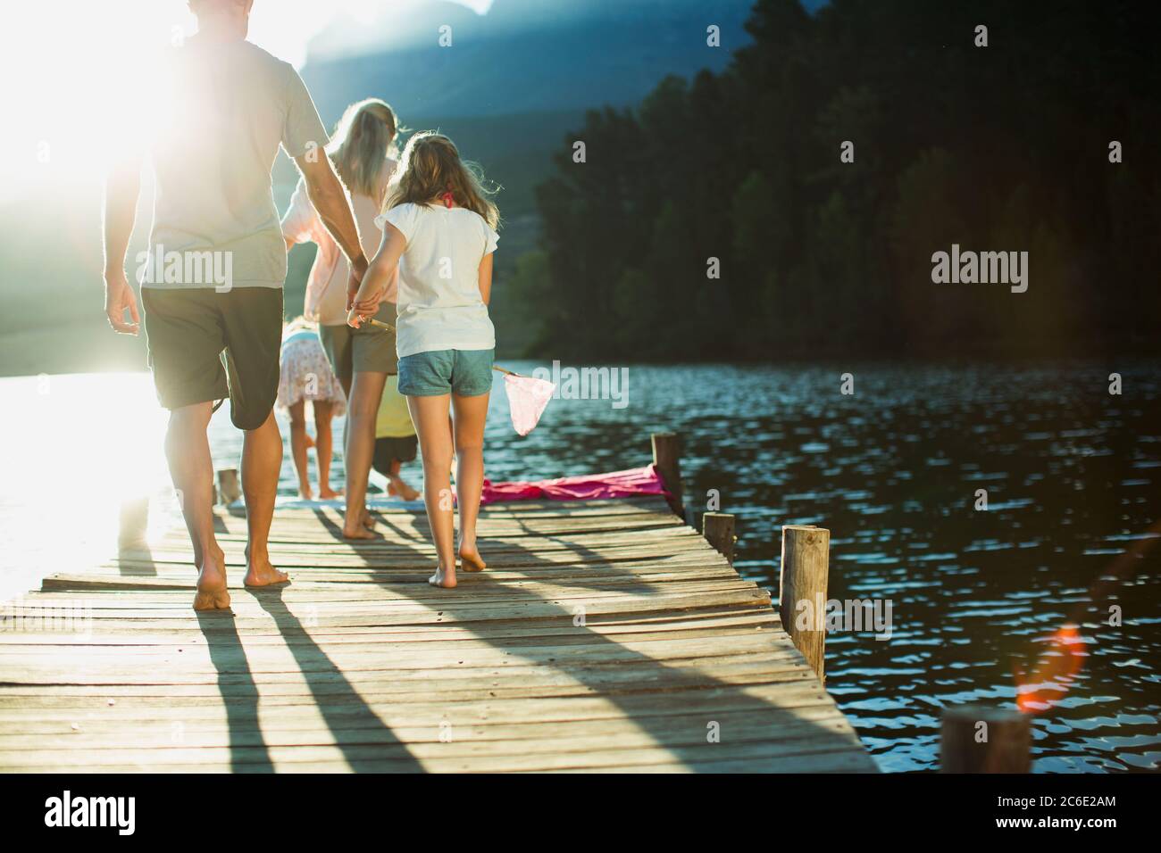 Family walking on dock over lake Stock Photo - Alamy