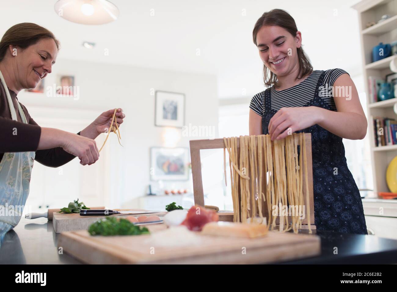 Mother and daughter making fresh homemade pasta in kitchen Stock Photo ...