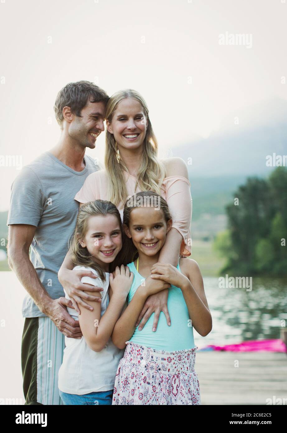 Smiling family on dock over lake Stock Photo - Alamy