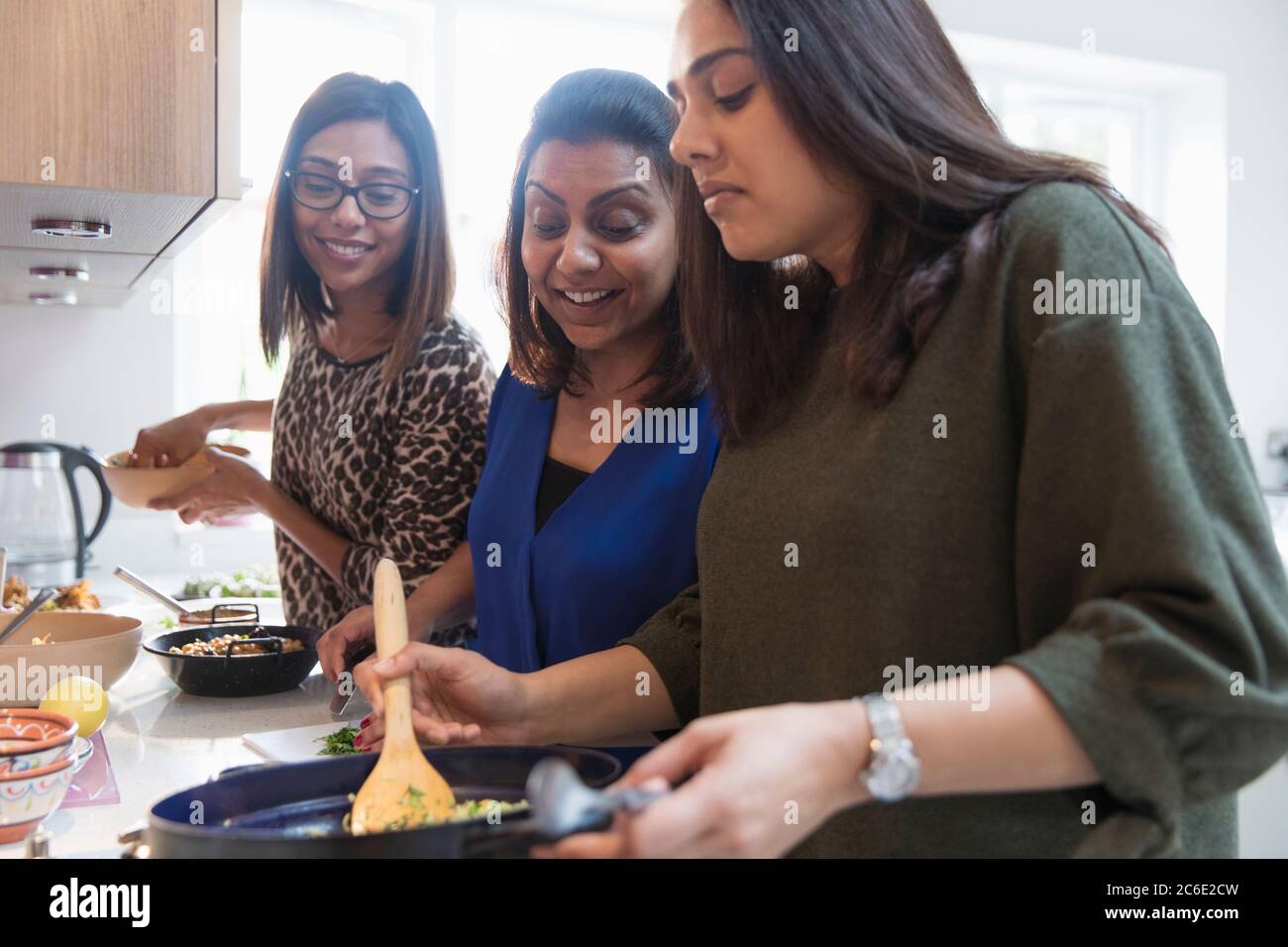 Happy Indian women cooking food in kitchen Stock Photo - Alamy