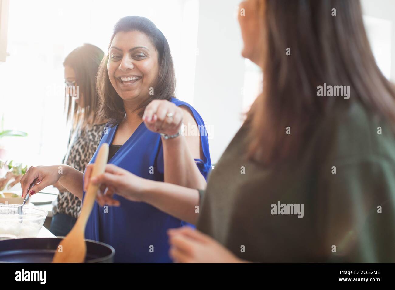 Happy Indian women cooking food in kitchen Stock Photo - Alamy