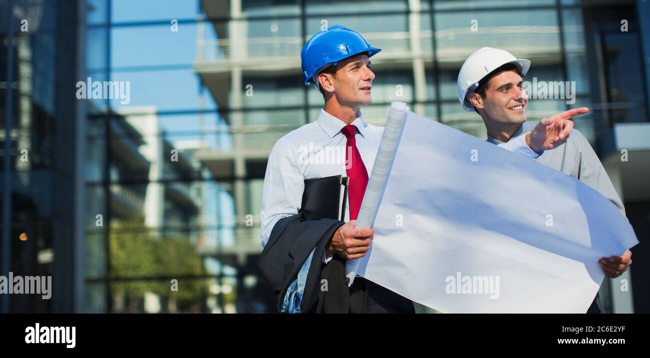 Architects with blueprints outside urban building Stock Photo - Alamy