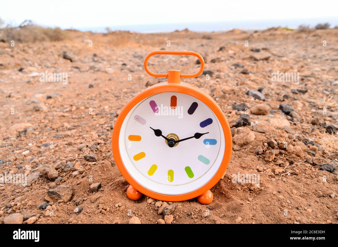 Classic Analog Clock In The Sand On The Rock Desert Stock Photo - Alamy