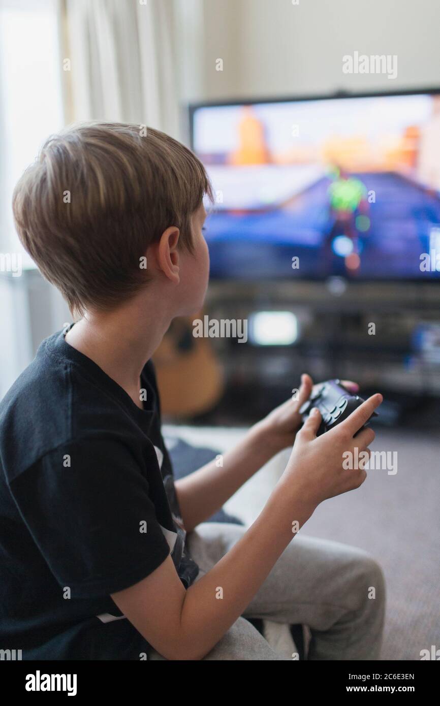 Boy playing video game at TV Stock Photo - Alamy