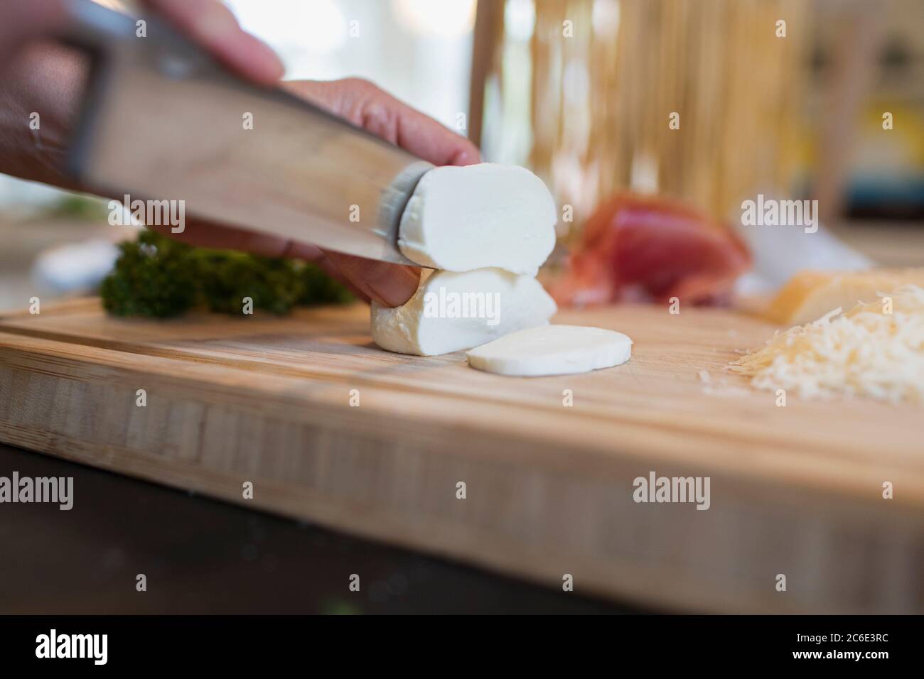Close up knife cutting into fresh mozzarella cheese Stock Photo - Alamy