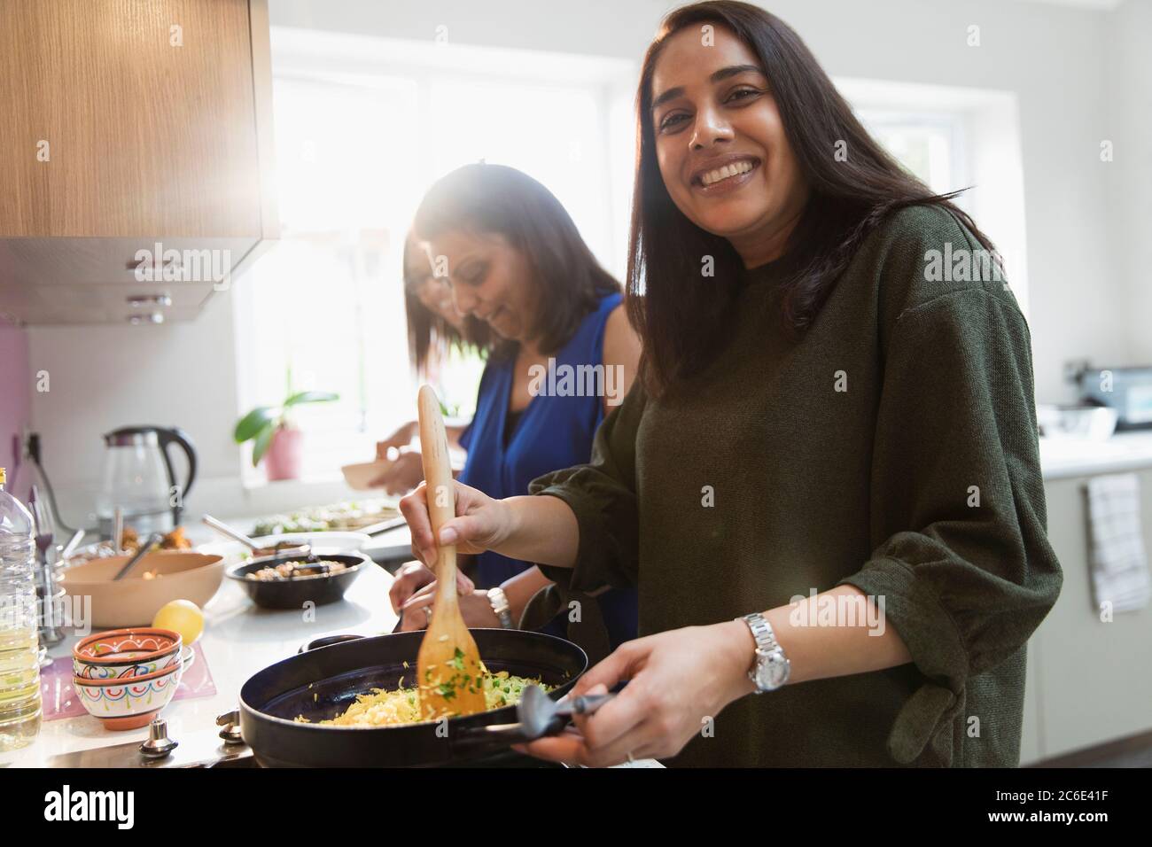 Portrait happy Indian woman cooking food at stove in kitchen Stock ...