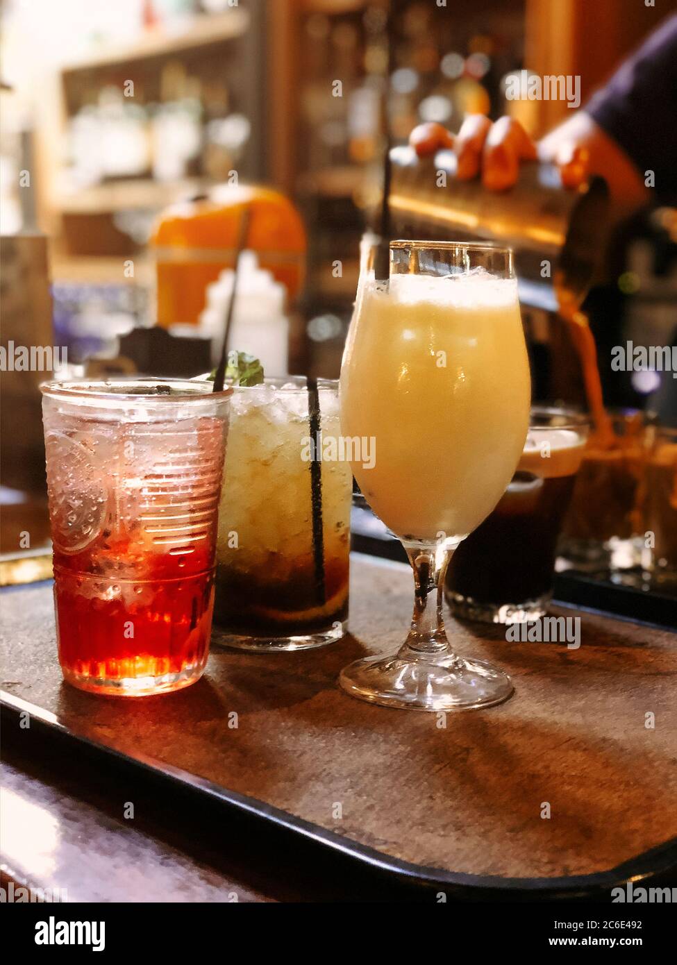Set of assorted alcohol beverages in glasses placed on tray on counter ...