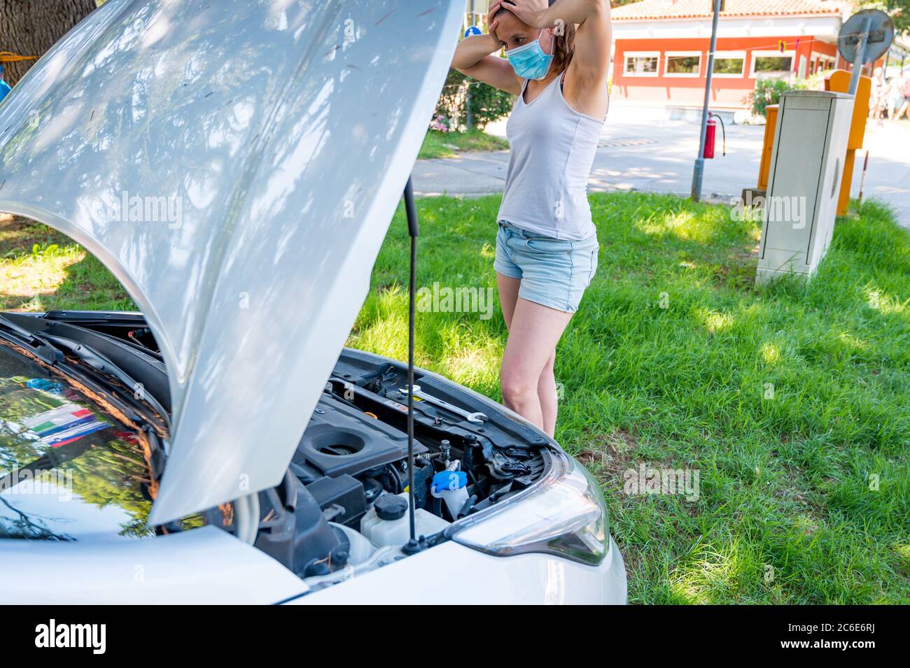 Woman wearing medical mask trying to fix broken car engine Stock Photo ...