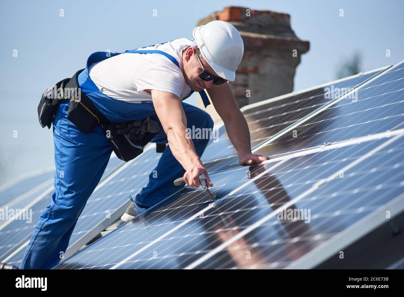 Male workers installing stand-alone solar photovoltaic panel system ...